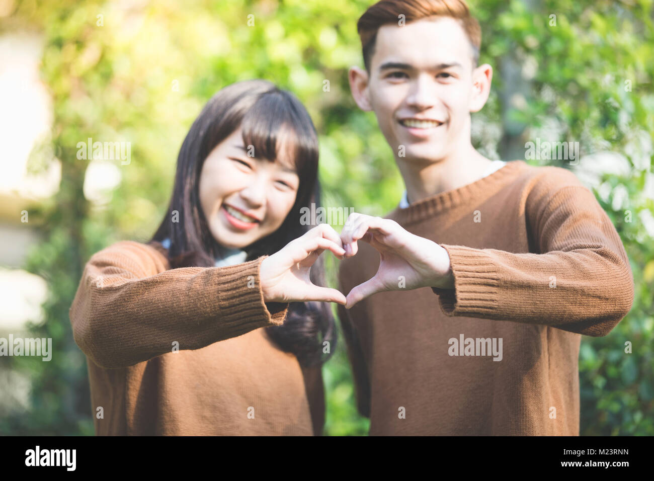 Beautiful young couple making heart shape with hands and Smiling happy ...
