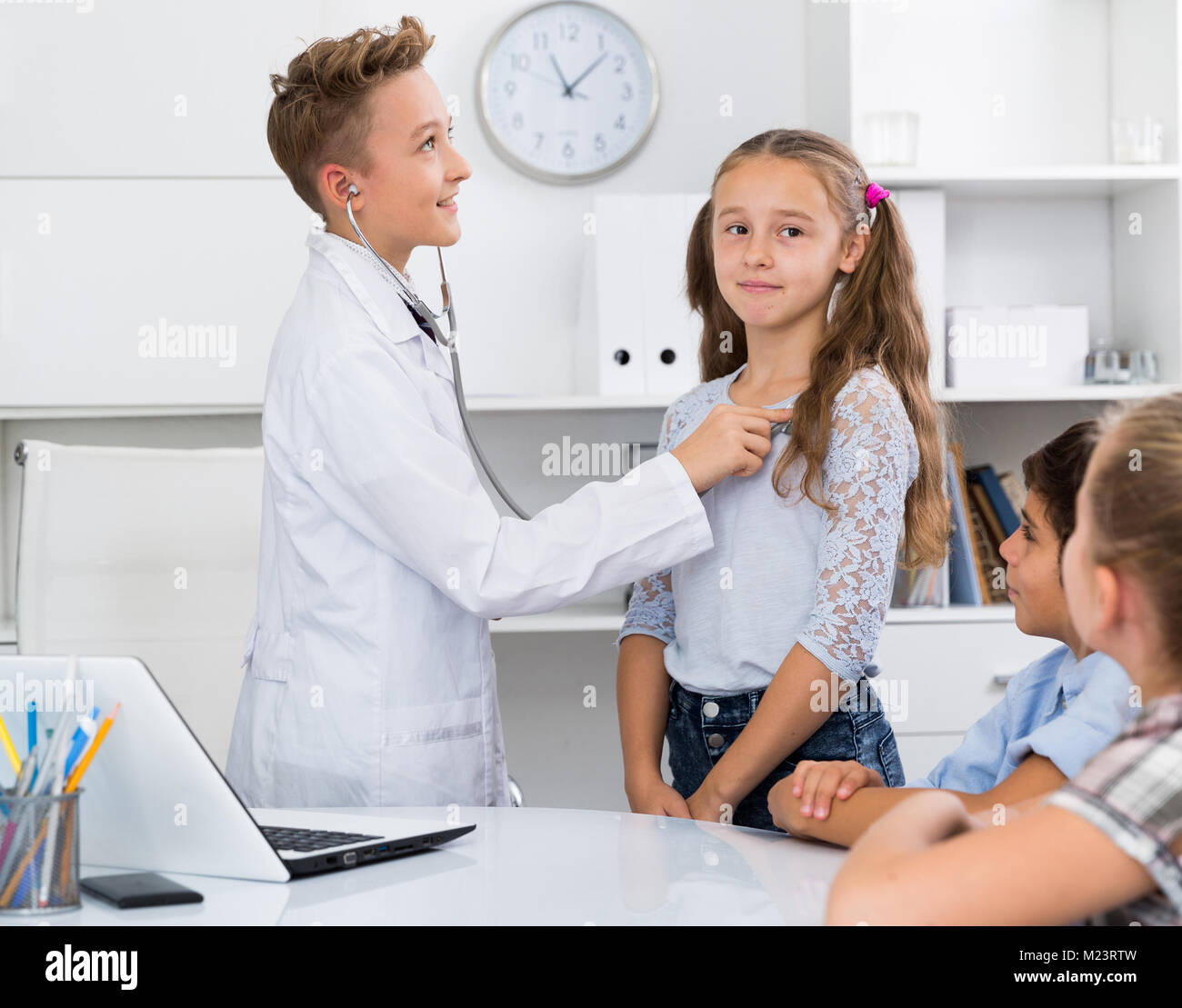 Medic boy with stethoscope with patient girl in the doctor's office ...