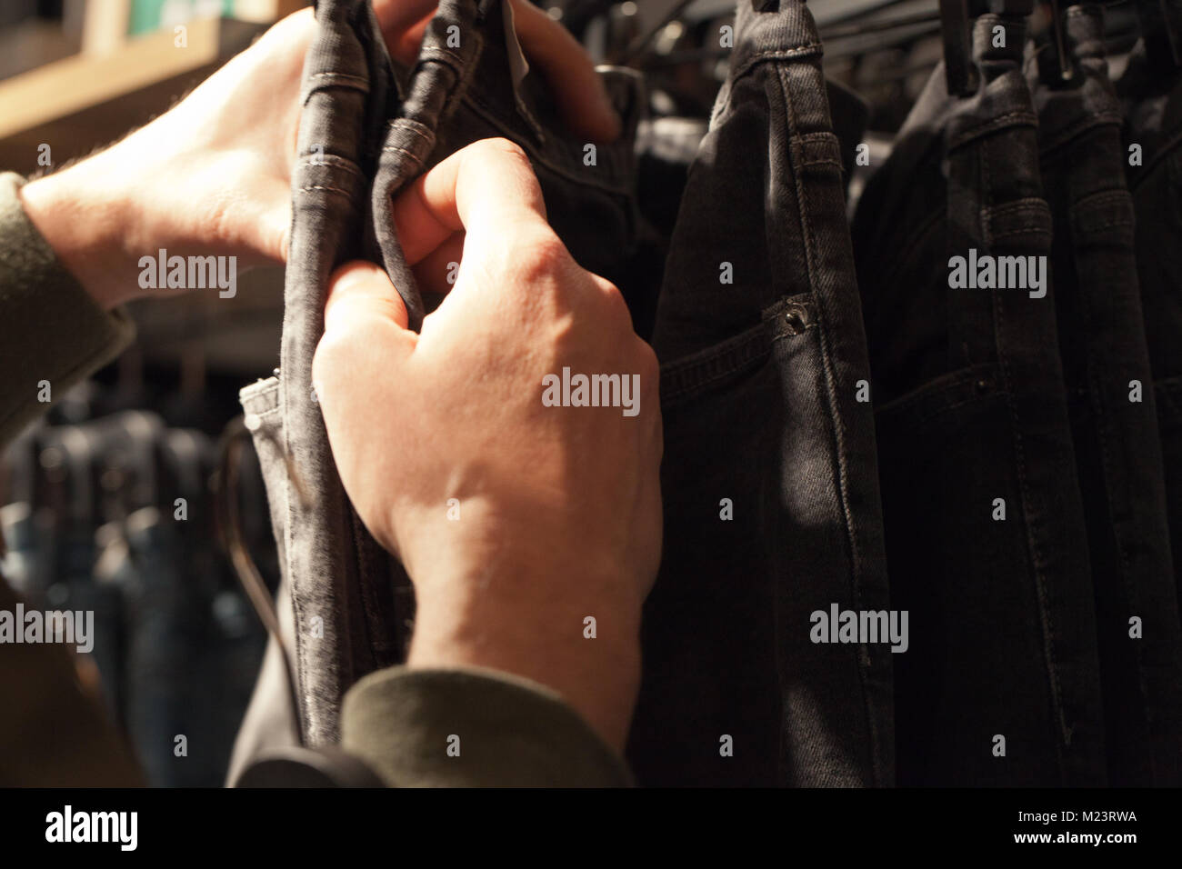 man holding clothes in a store during shopping Stock Photo - Alamy