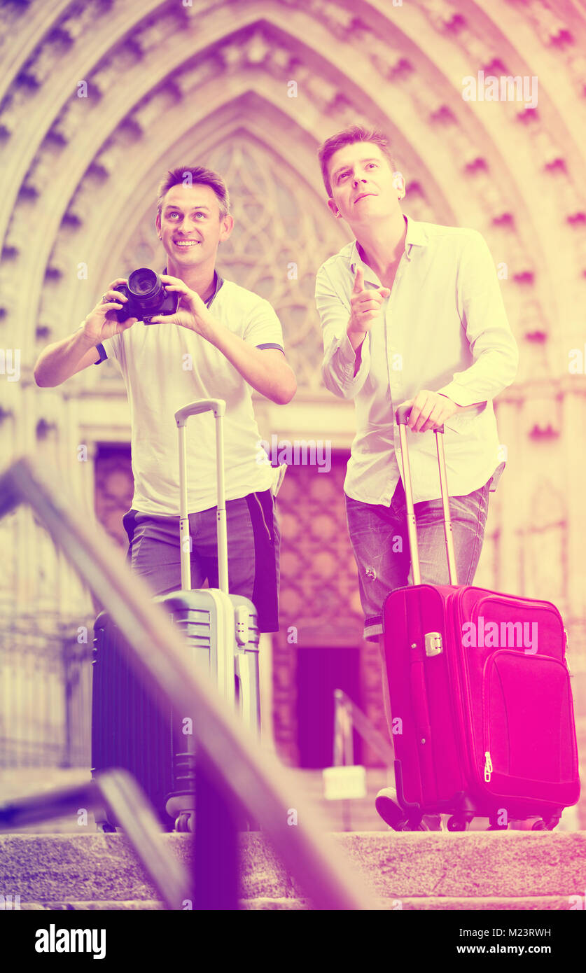 Handsome male couple sightseeing and taking pictures of Europenian city ...