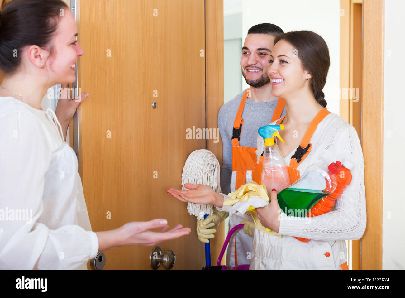 Professional positive cleaners with equipment standing at doors of ...