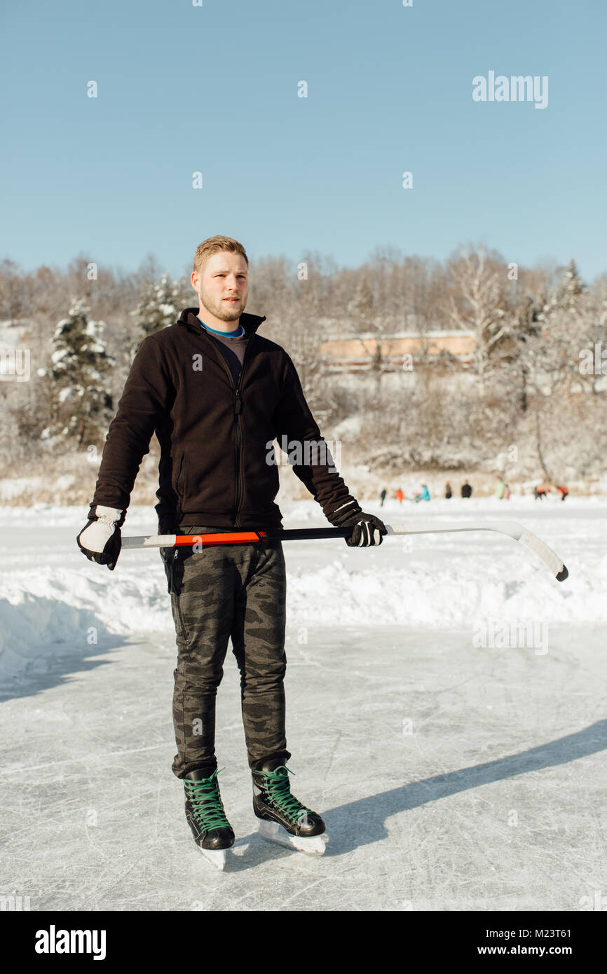 Man wearing ice skates holding a stick Stock Photo - Alamy