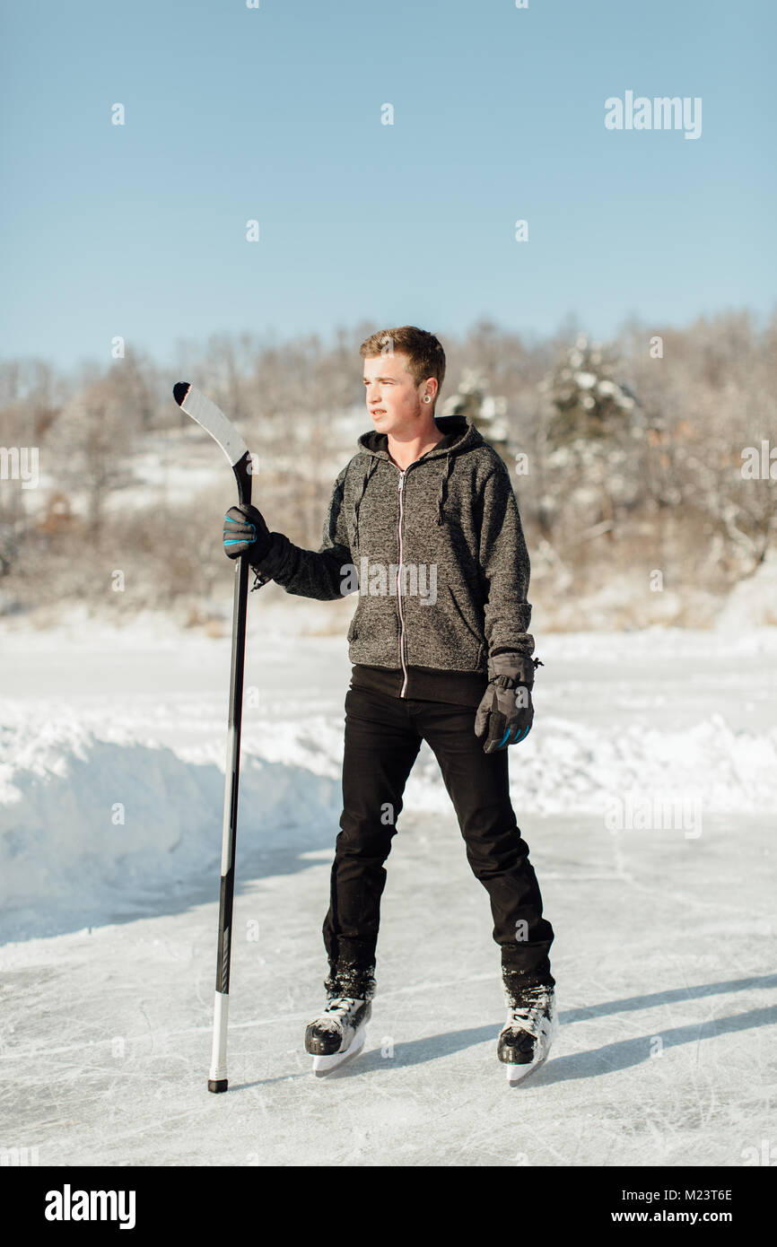 Man wearing ice skates holding a stick Stock Photo - Alamy