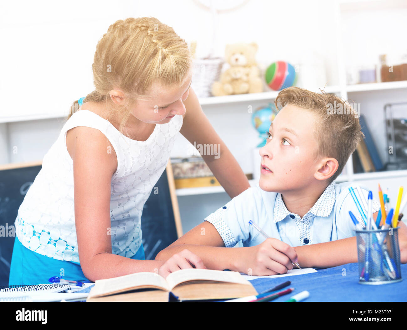 Sister is helping brother with homework at home Stock Photo - Alamy