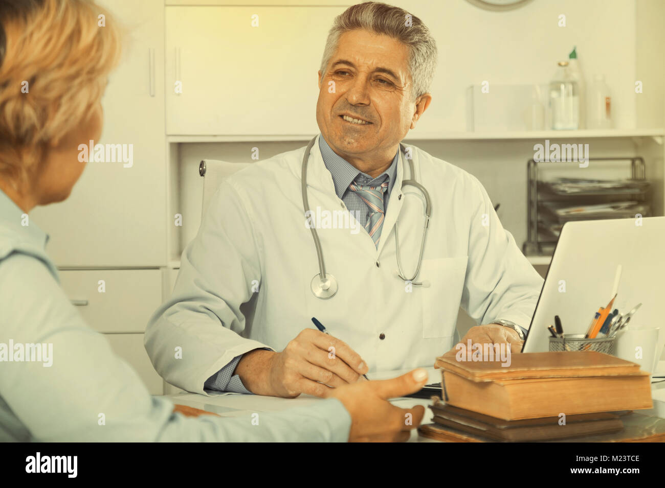 Mature professor of medicine advising his colleague on scientific ...