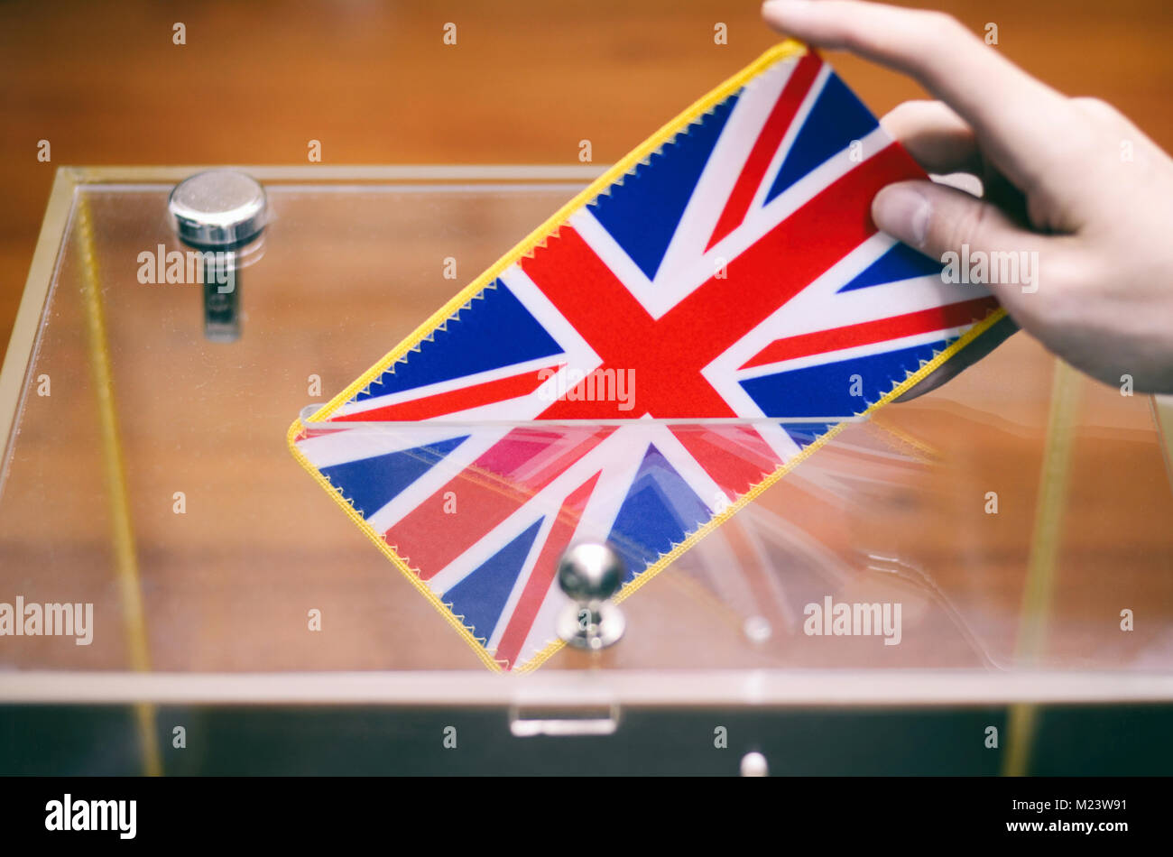 Man inserting United Kingdom flag into ballot box, voting and elections ...
