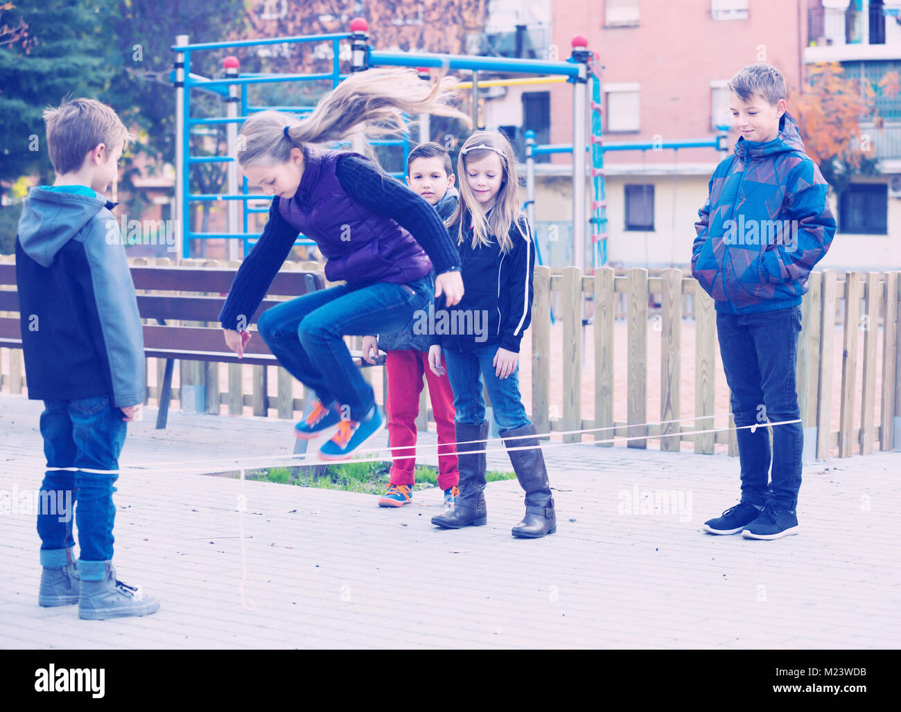 Friendly kids skipping on chinese jumping elastic rope in yard Stock ...