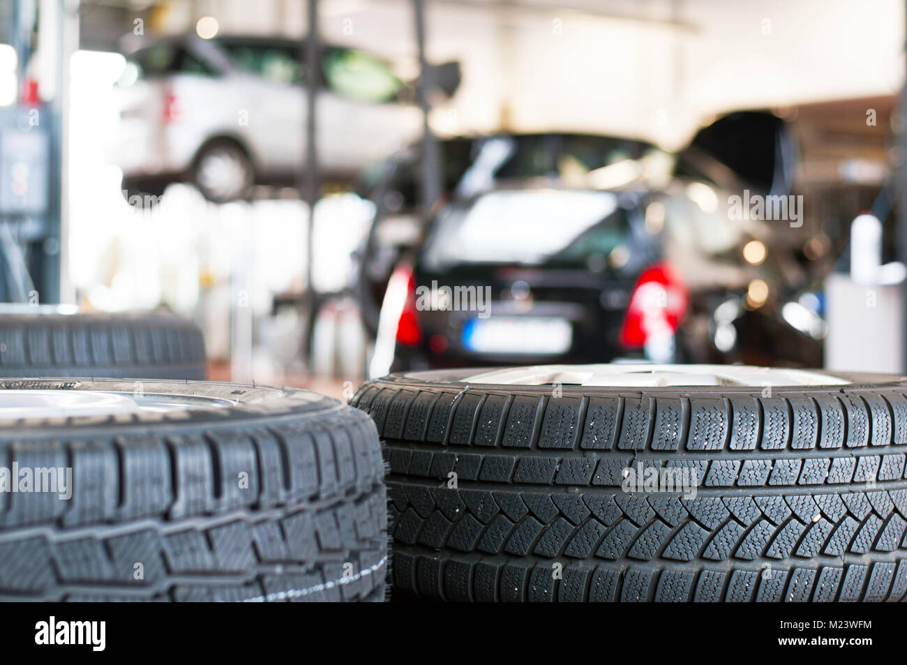 tyre change in a garage - closeup tyre tread - stack tyres for sales ...