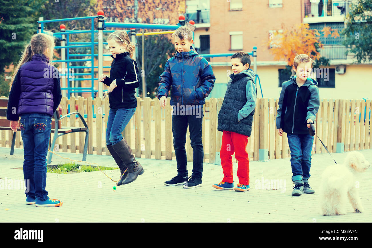 positive european children playing rubber band jumping game and ...