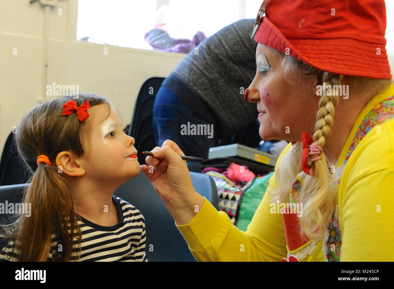 Dee Dee the Clown applying make-up to a small child shortly before the ...
