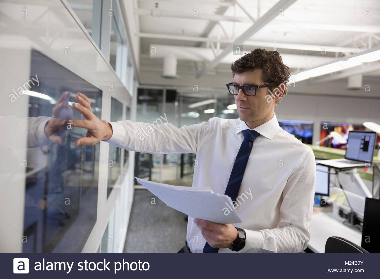 Businessman with paperwork using touch screen in office Stock Photo - Alamy