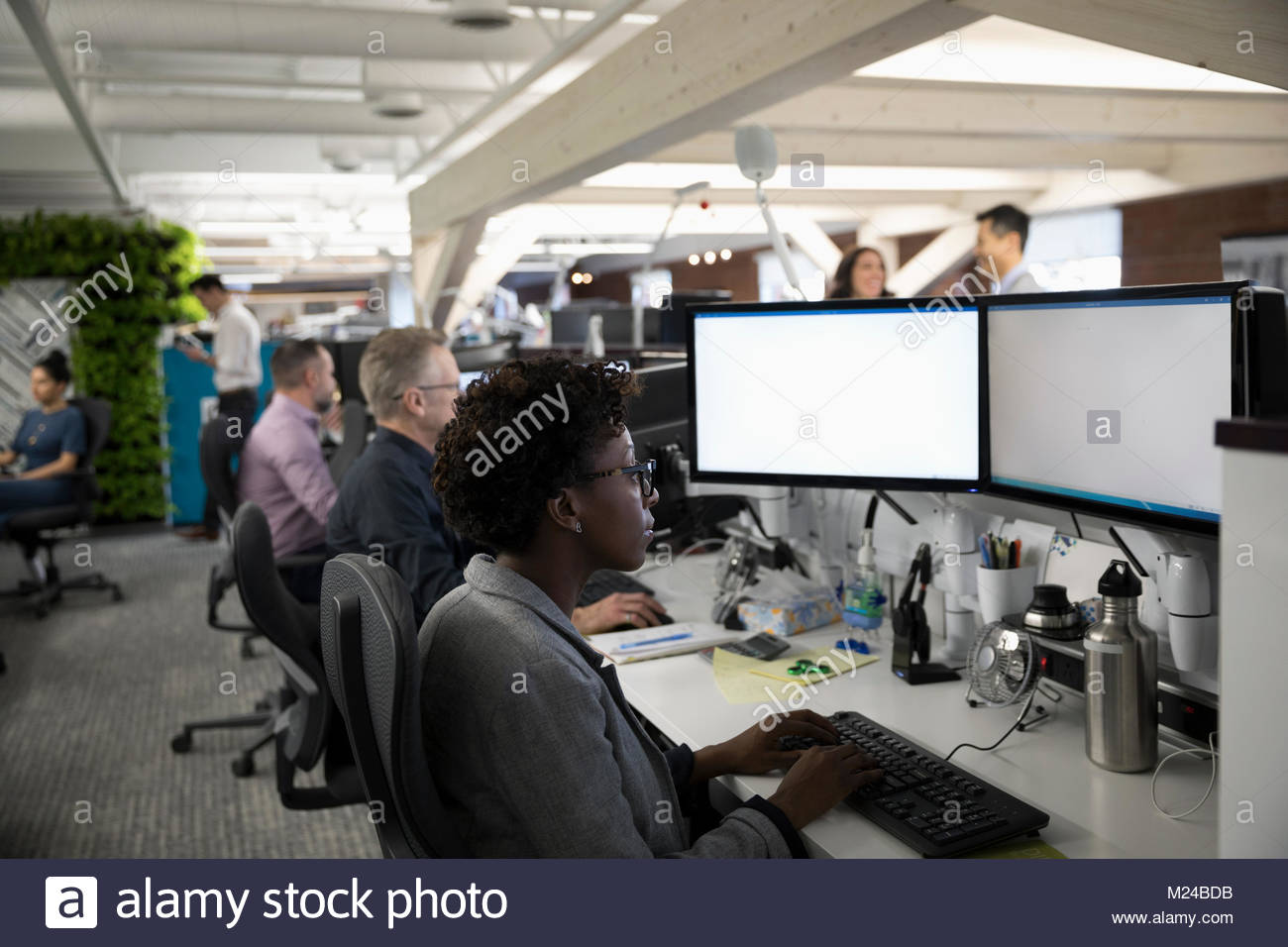 Business people working at computers in open plan office Stock Photo ...