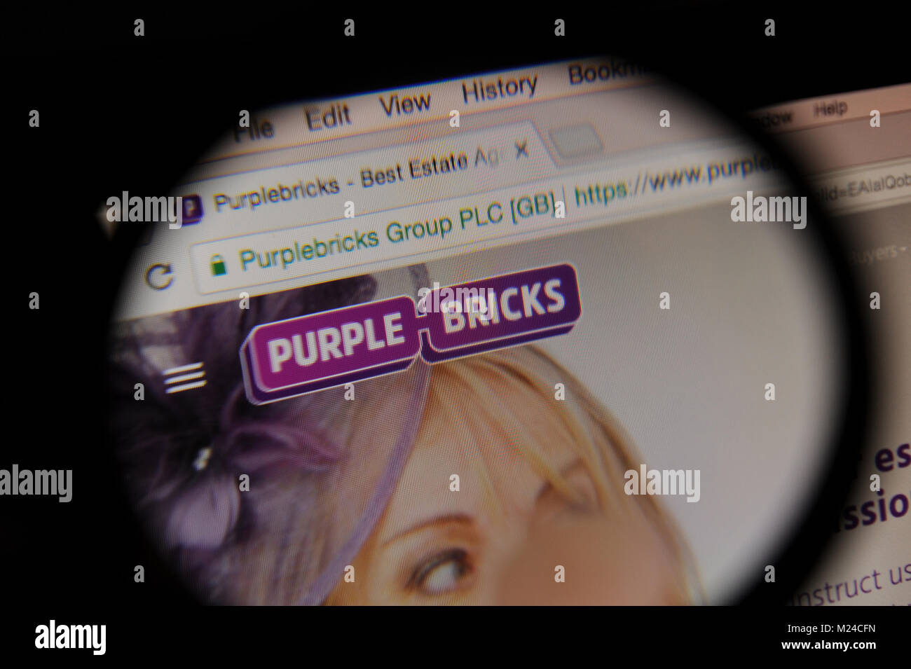 The PurpleBricks website seen through a magnifying glass Stock Photo ...