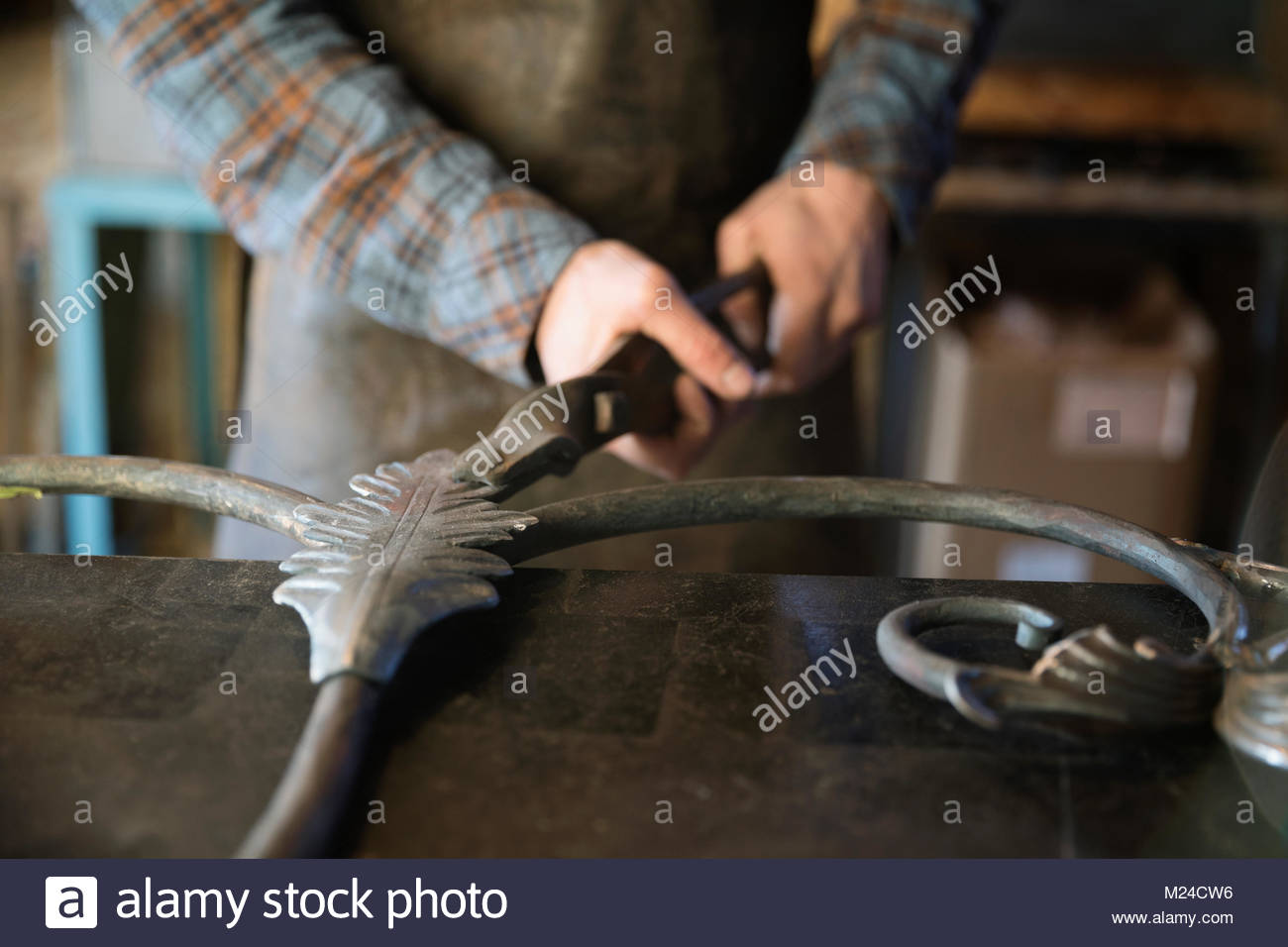 Male blacksmith hand shaping scrolled metal Stock Photo - Alamy