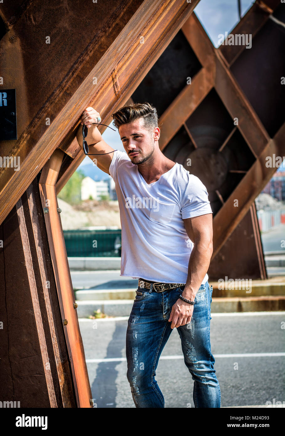 Man in urban setting in front of big metal structure Stock Photo - Alamy
