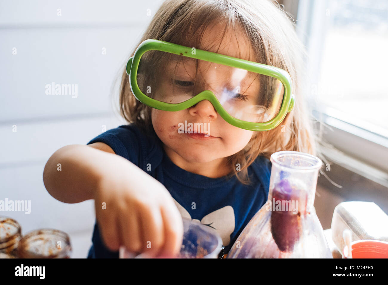 A 3-year old toddler girl works with science experiment equipment Stock ...