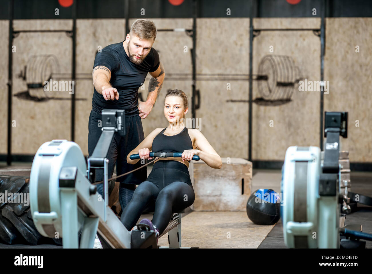 Coach training woman on the exercise machine Stock Photo - Alamy