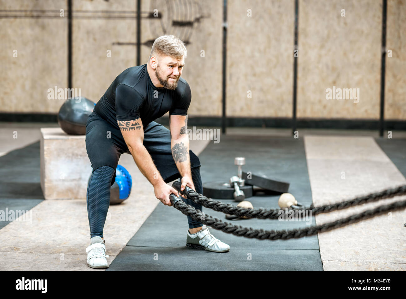 Man training with a rope in the gym Stock Photo - Alamy