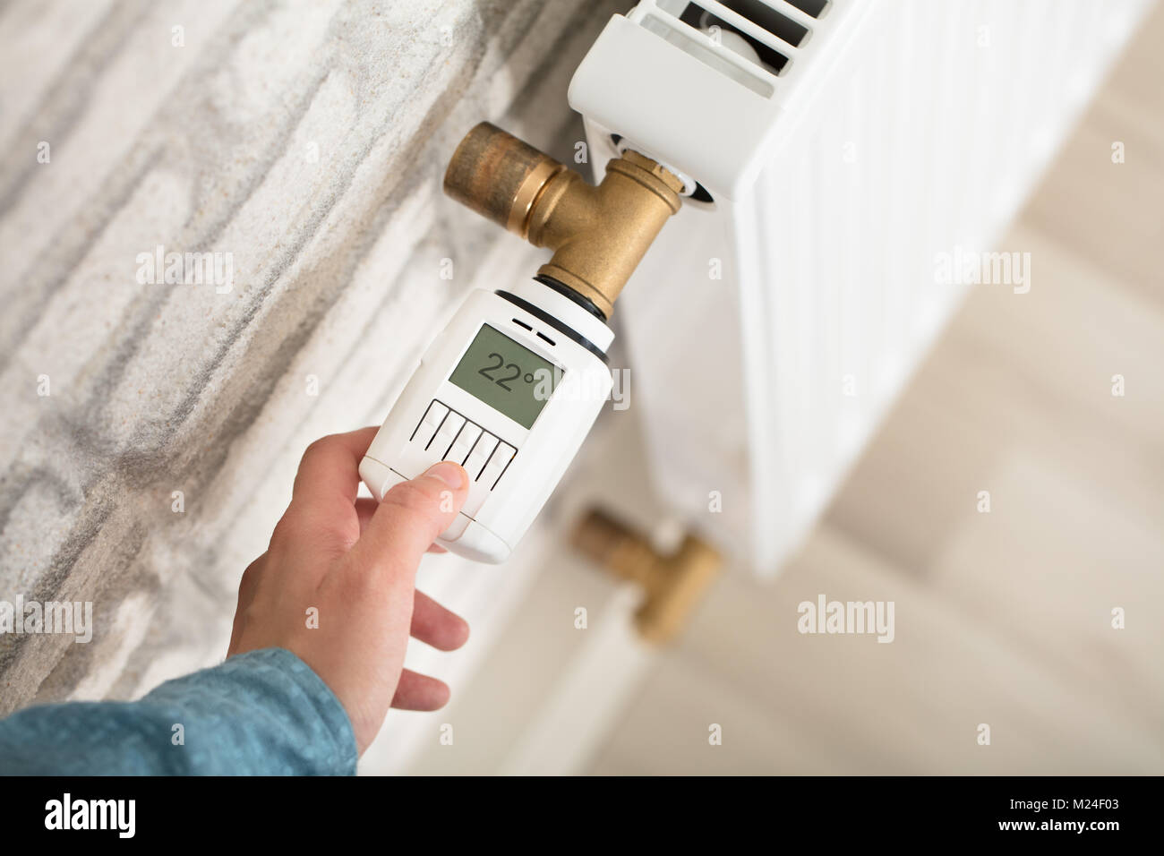 A Person's Hand Adjusting Temperature On Thermostat Of Radiator Stock ...