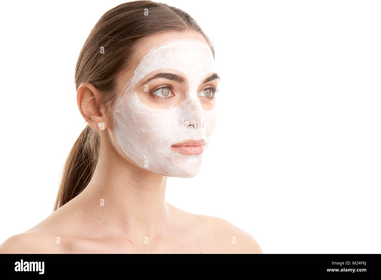 Close-up shot of young woman with a mask applied to her face. Isolated ...