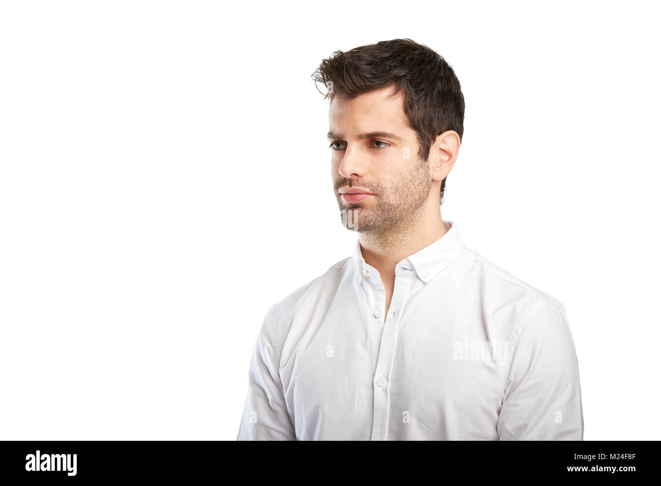 Portrait of young man standing at isolated white background and looking ...
