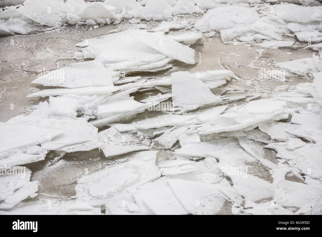 snow covered formed pack ice on the background of winter river water ...