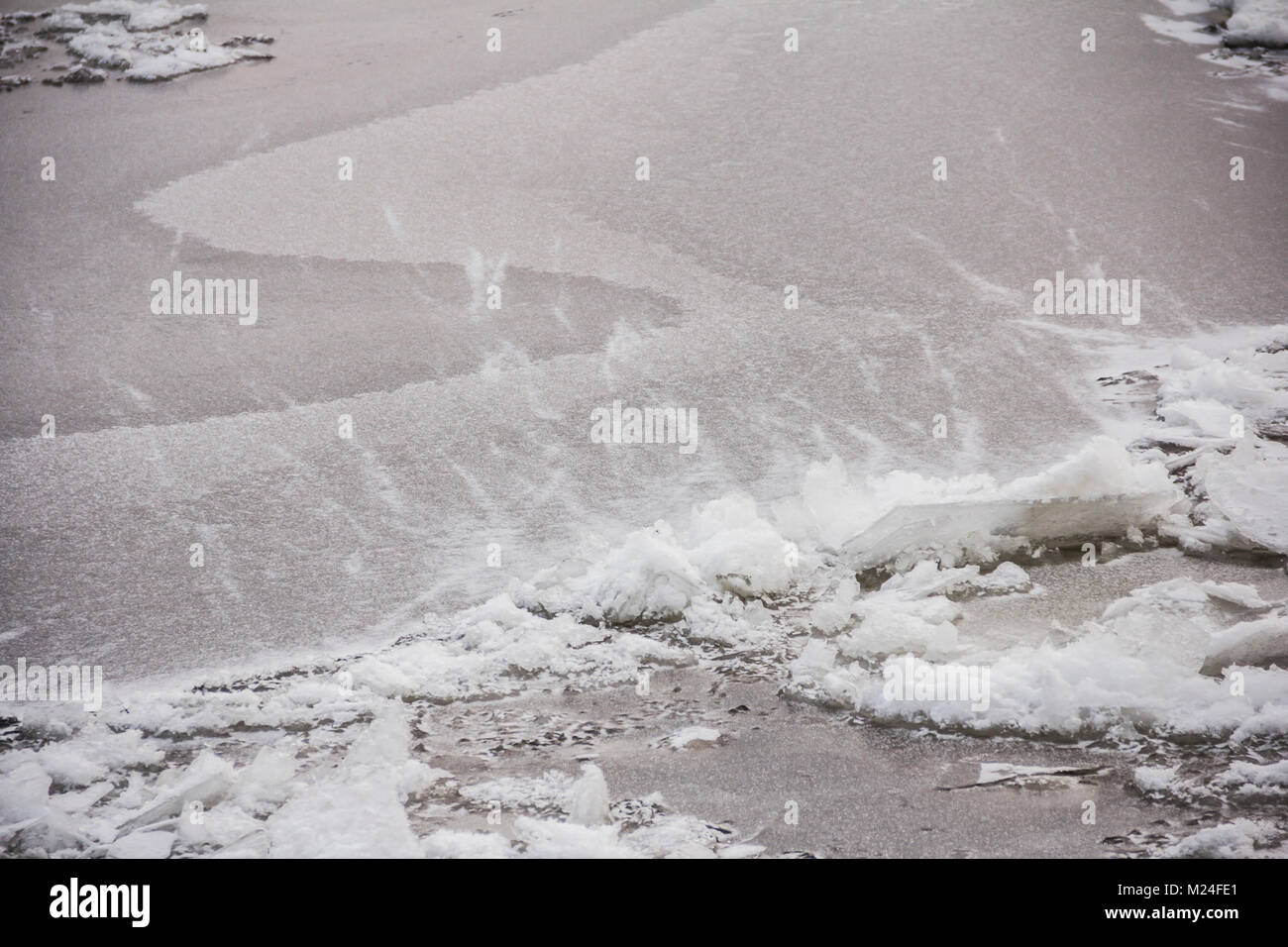 snow covered formed pack ice on the background of winter river water ...