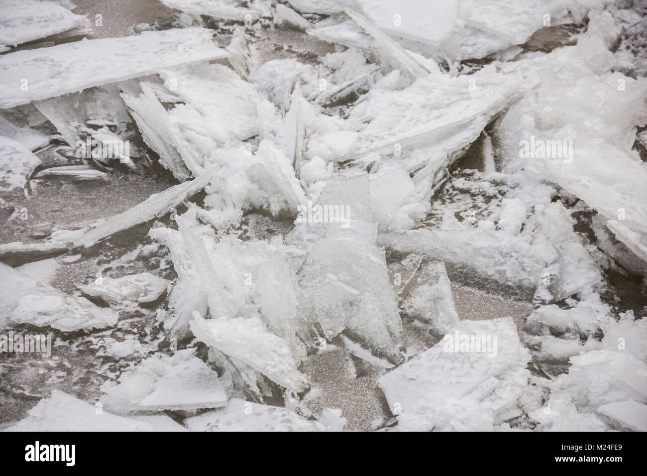 snow covered formed pack ice on the background of winter river water ...
