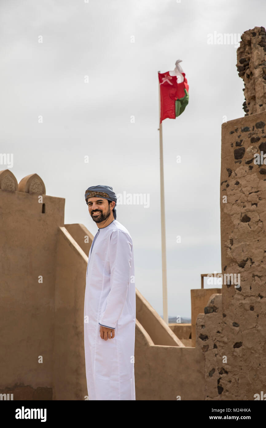 omani man smiling with omani flag flying at the background Stock Photo ...