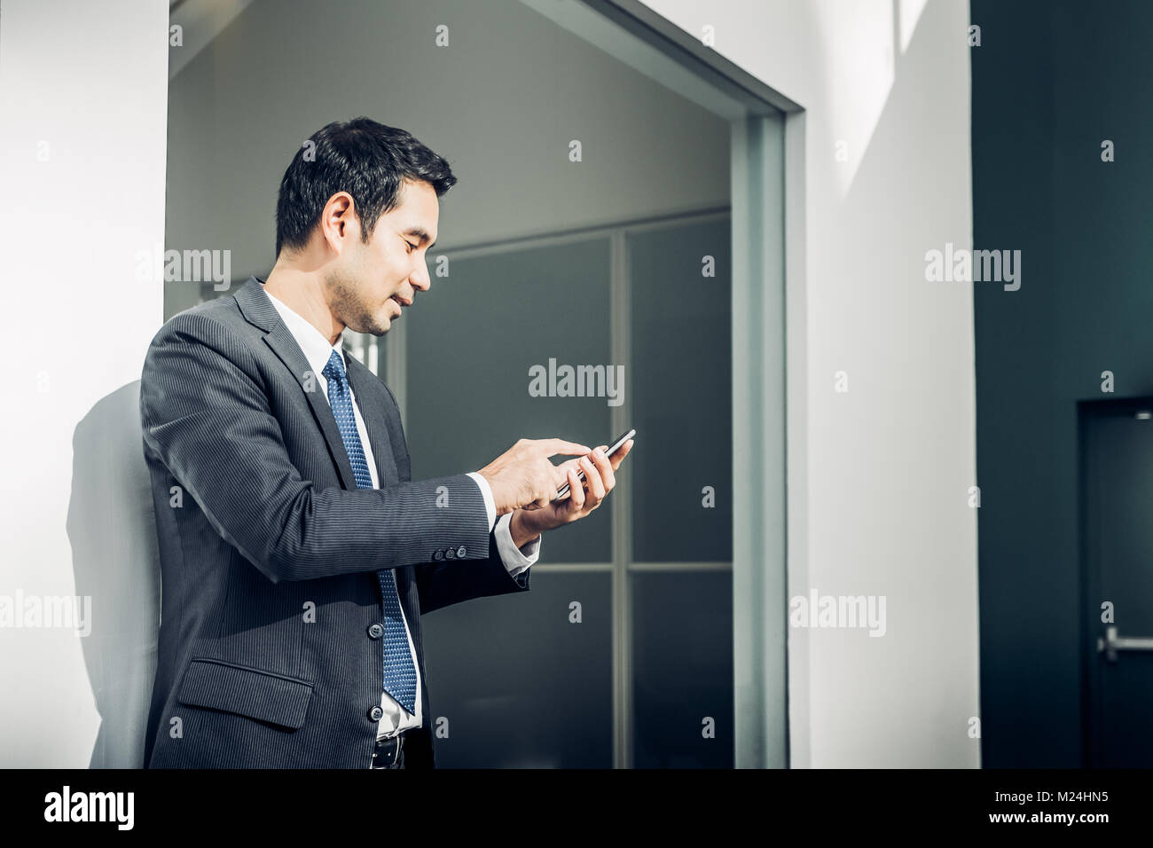Businessman using mobile phone indise office building Stock Photo - Alamy