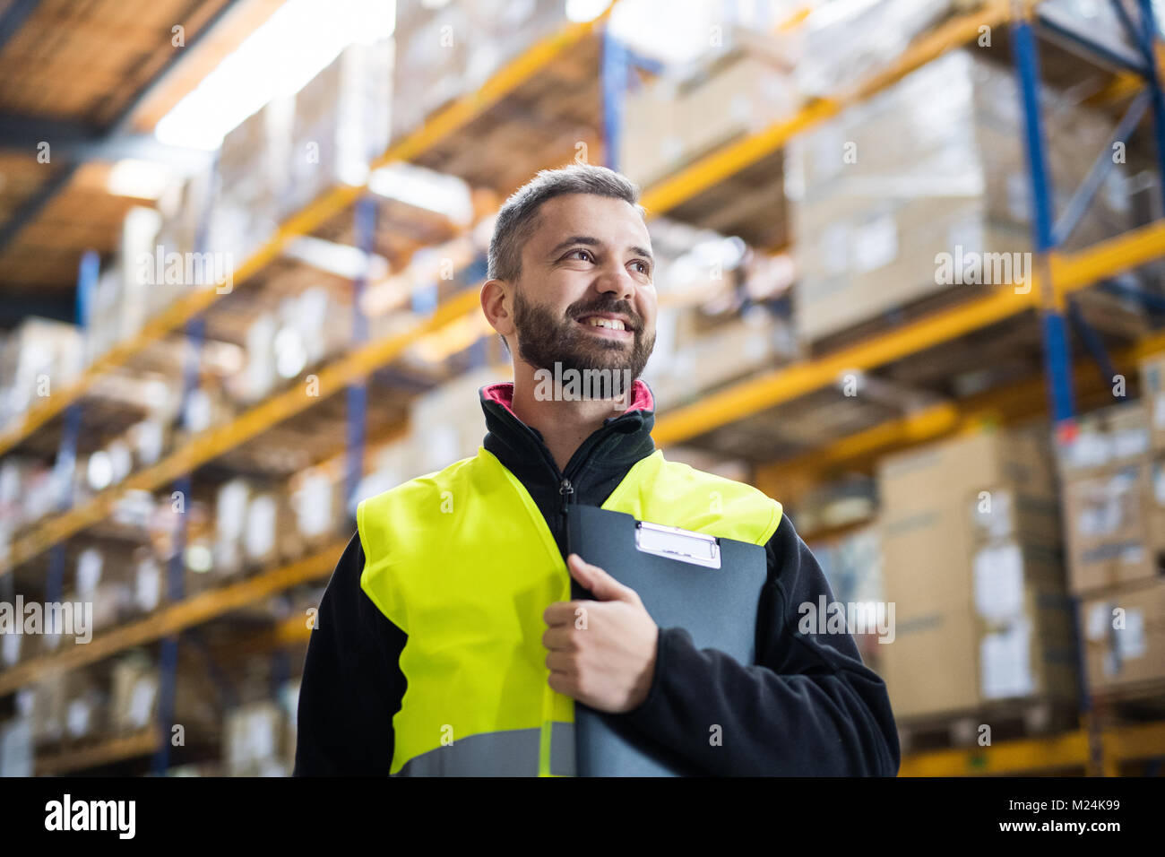 Male warehouse worker with clipboard Stock Photo - Alamy