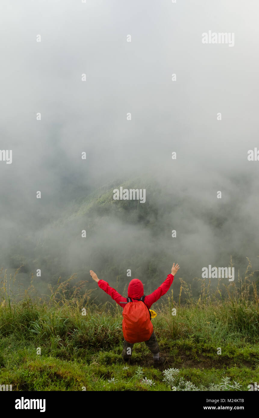 Man Traveler on mountain summit enjoying aerial view hands raised over ...