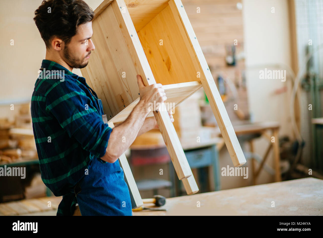 carpenter testing wood plank evenness at workshop Stock Photo - Alamy