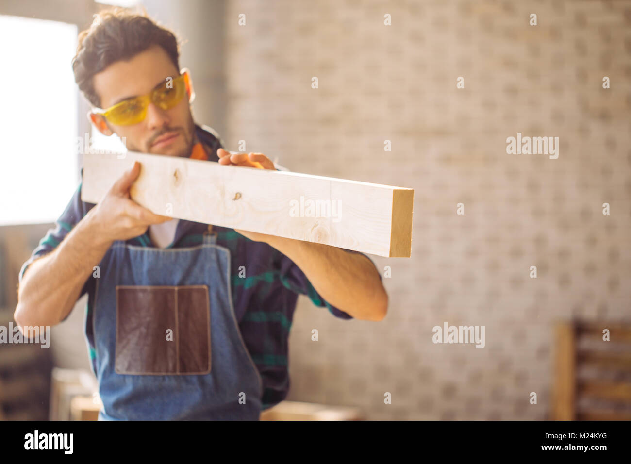carpenter testing wood plank evenness at workshop Stock Photo - Alamy