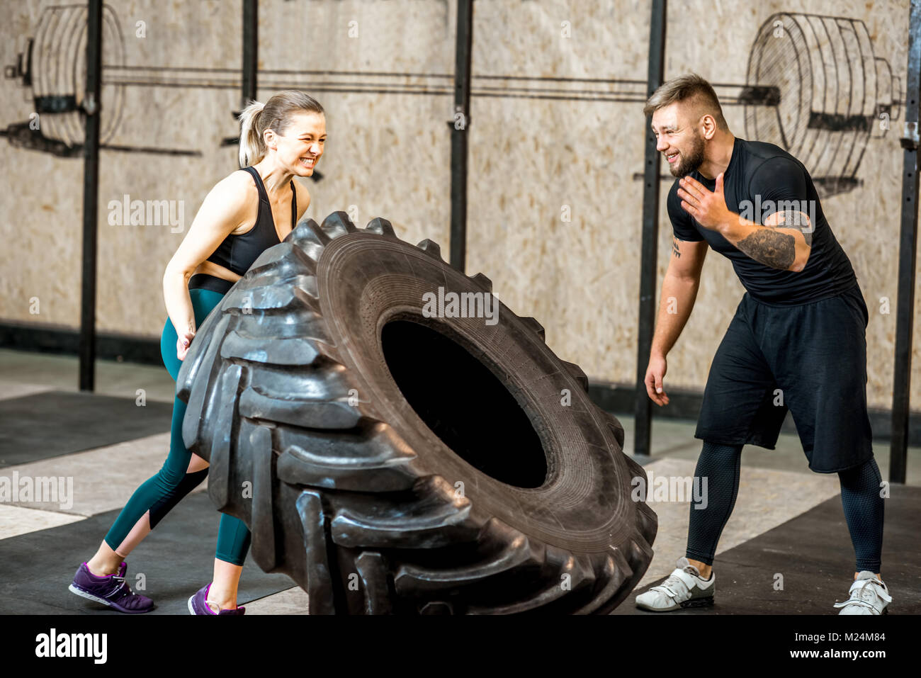 Woman pushing a tire in the gym Stock Photo - Alamy