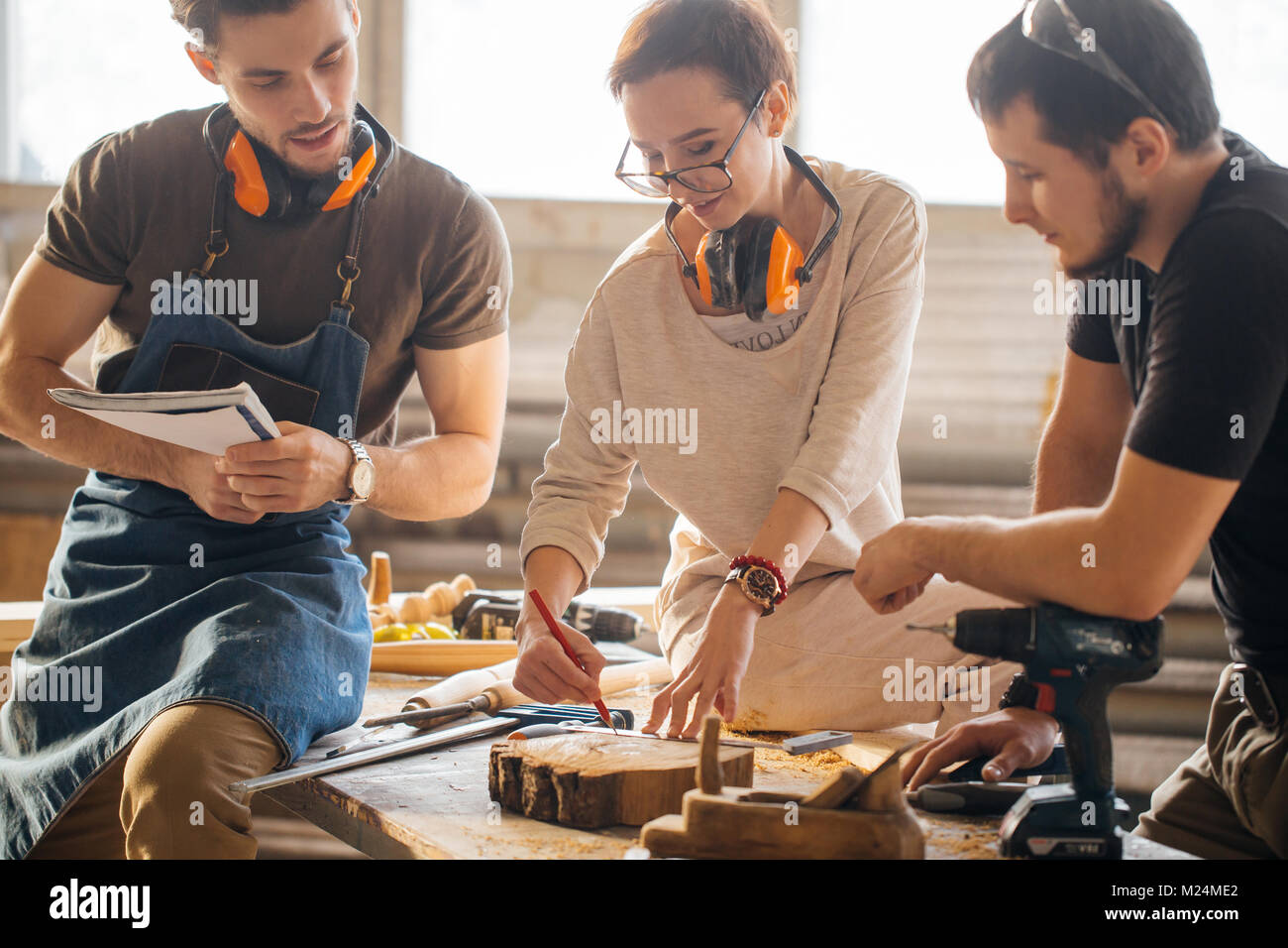 Carpenter Training Female Apprentice To Use Plane Stock Photo - Alamy