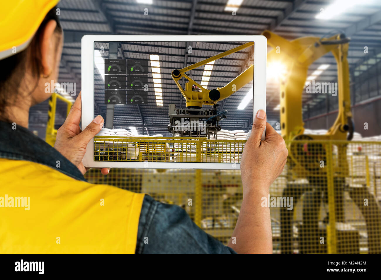 Engineer hand using tablet, heavy automation robot arm machine in smart factory industrial with ...