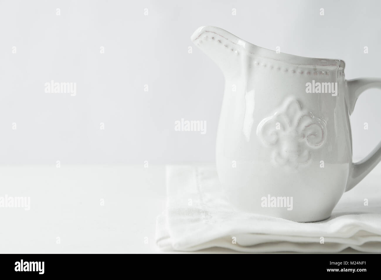 White Vintage Ceramic Cream Milk Jug Standing on Folded White Cotton ...