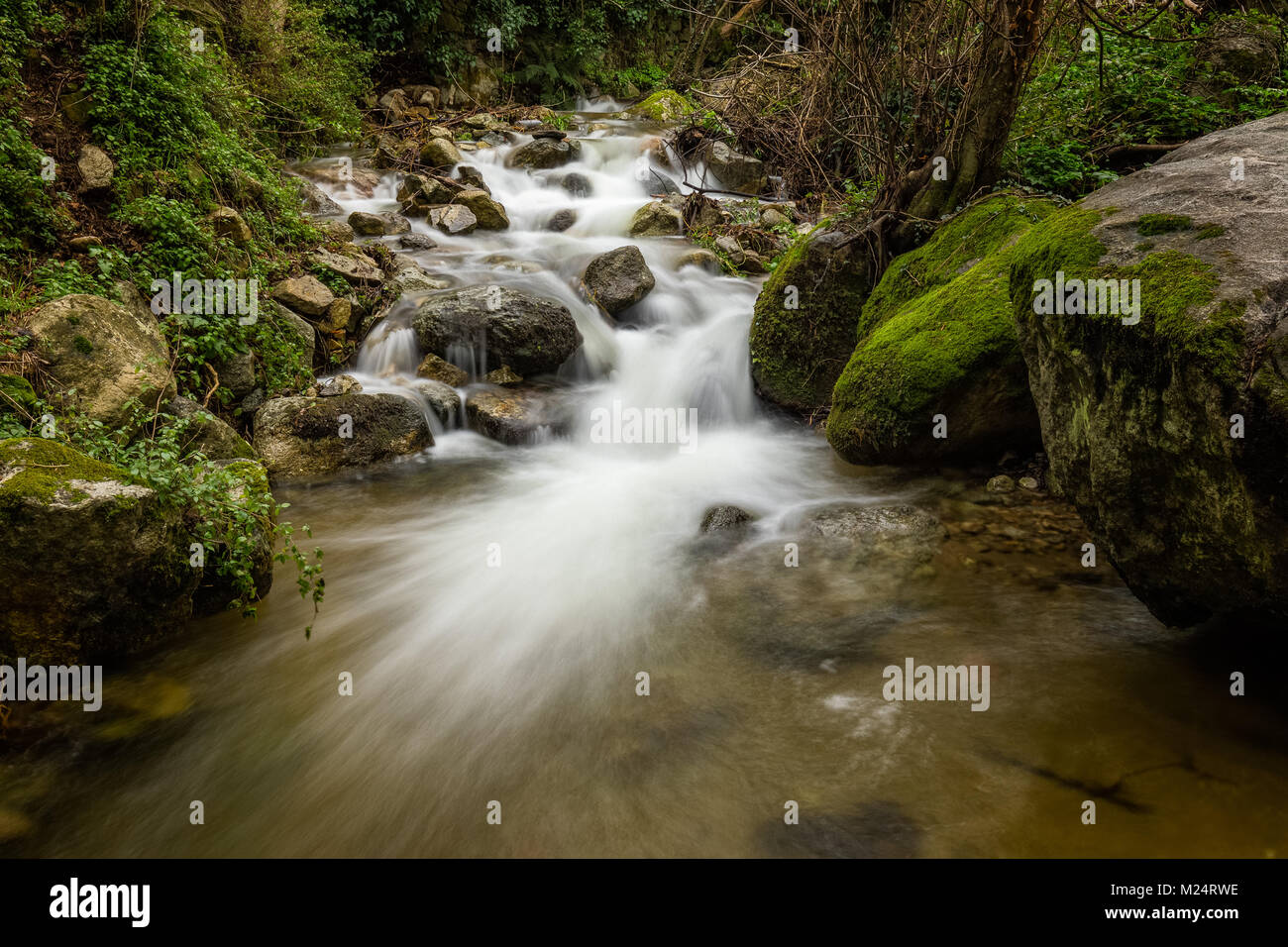 Slow shutter image of a cascading mountain stream falling over rocks ...