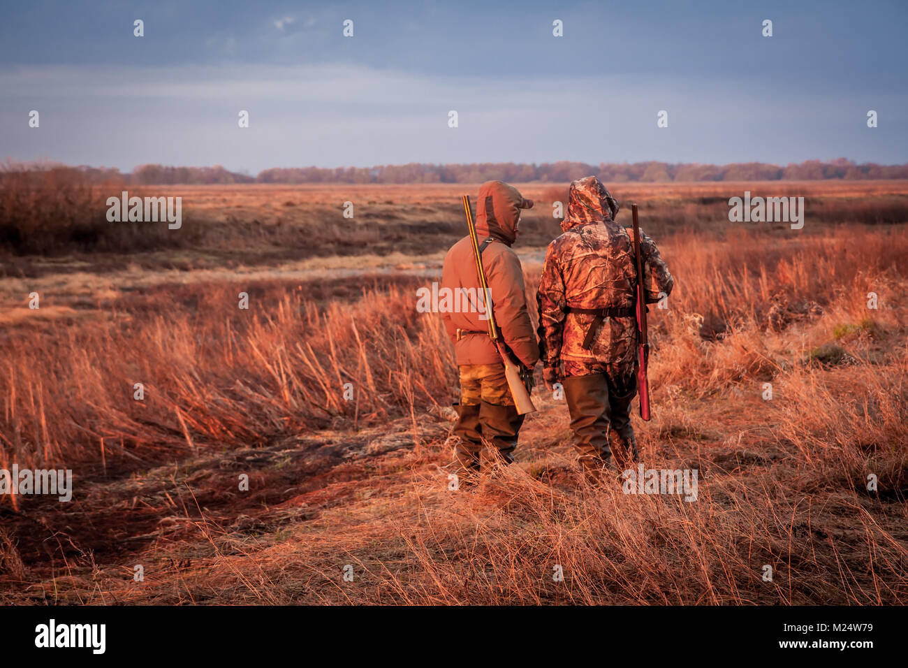 Hunters hunting in rural field during sunrise. Field painted with ...