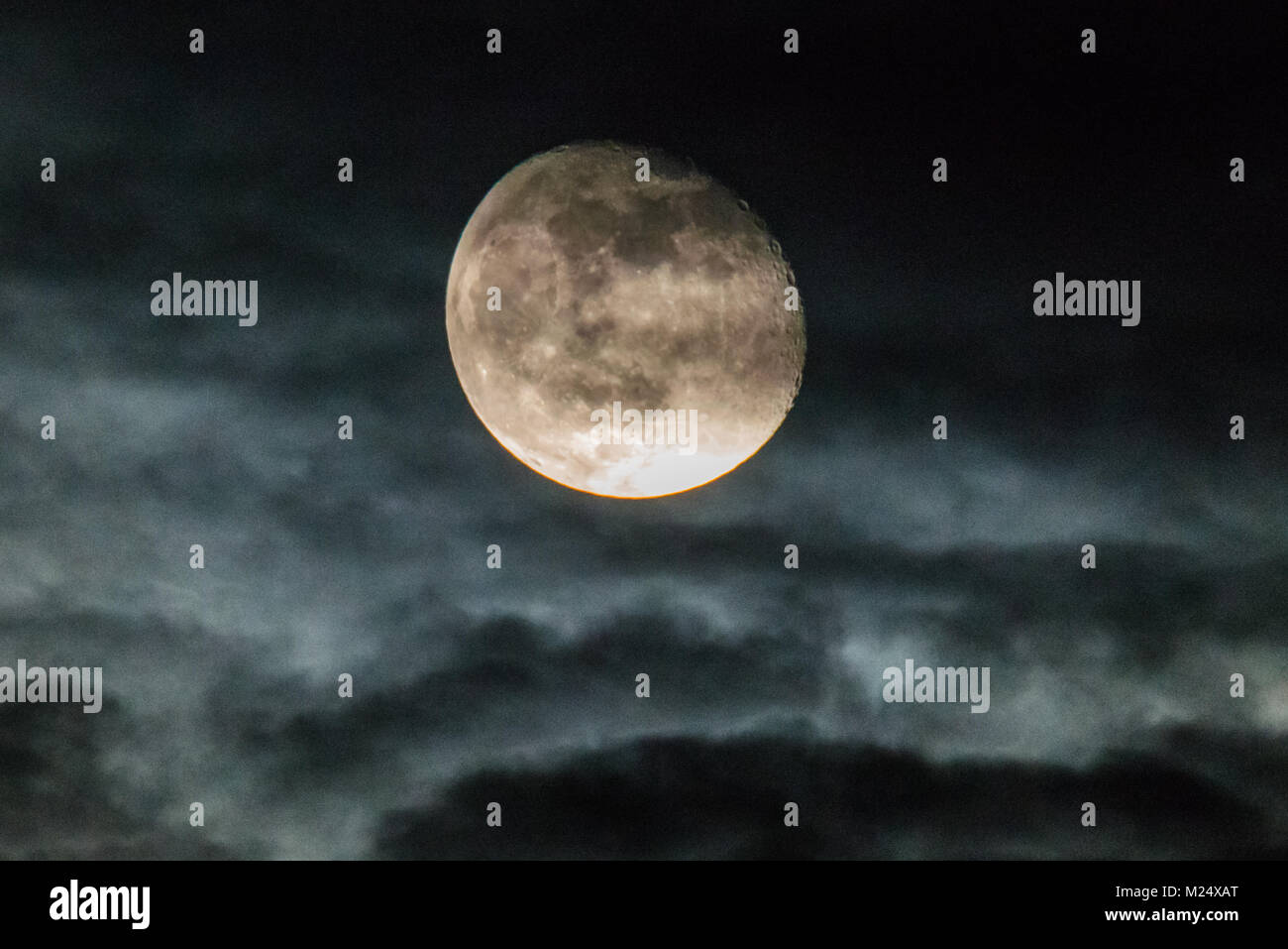 Near Full Moon and cloudy sky Stock Photo - Alamy