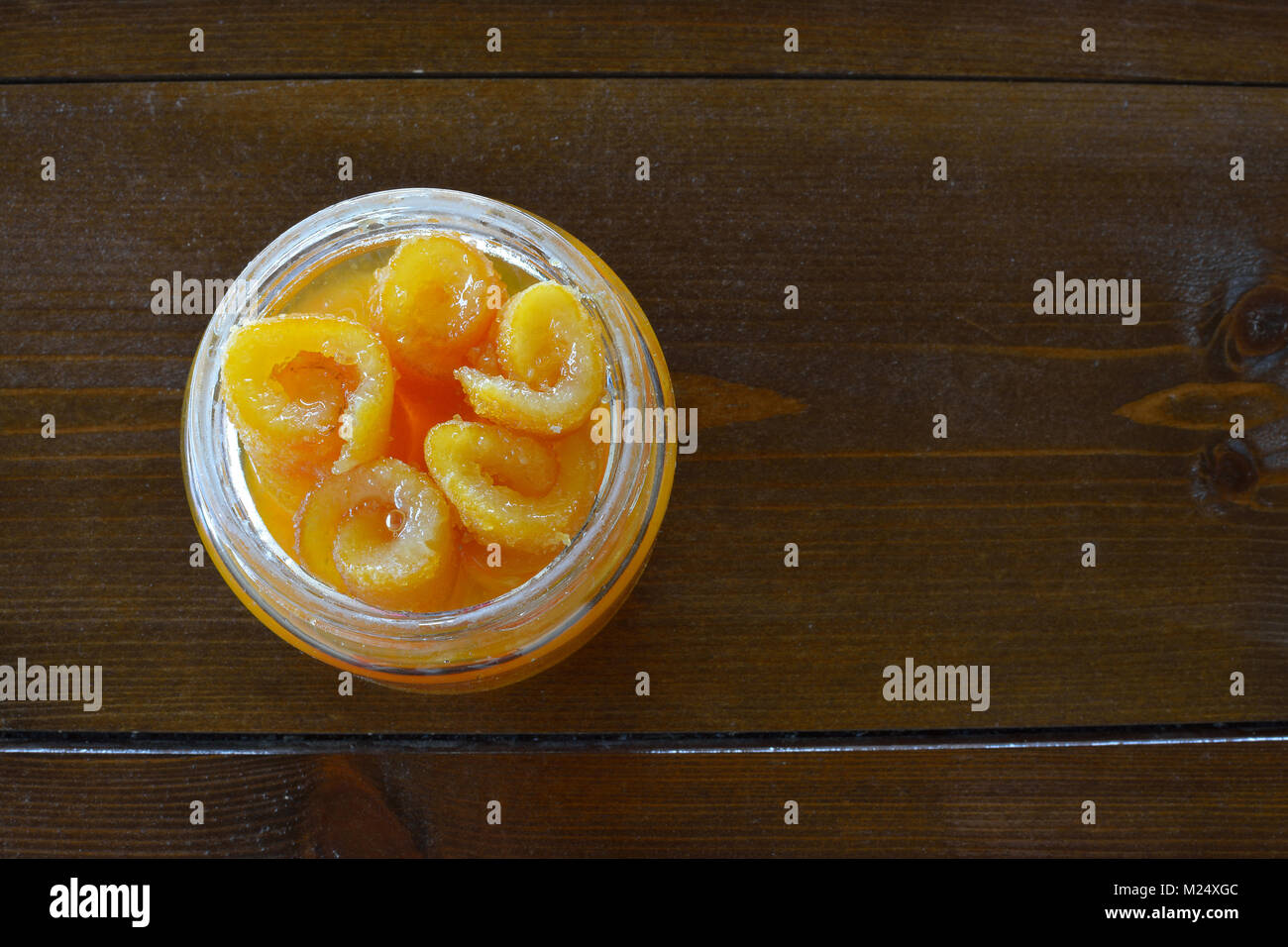 An open vase of preserved oranges on a wooden table Stock Photo - Alamy