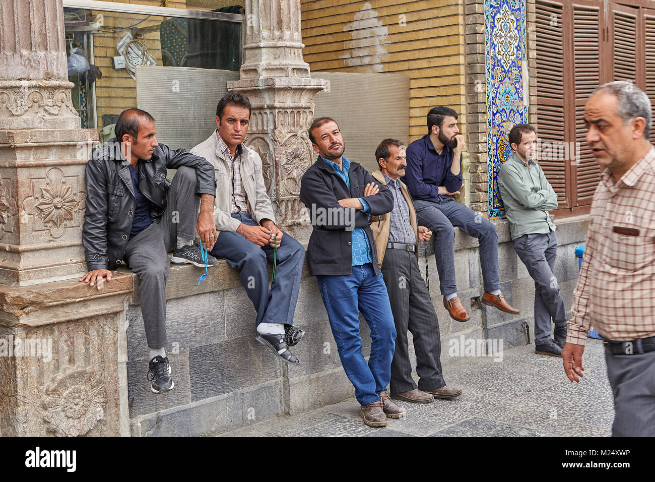 Tehran, Iran - April 27, 2017: Iranian men sit near a column in the ...