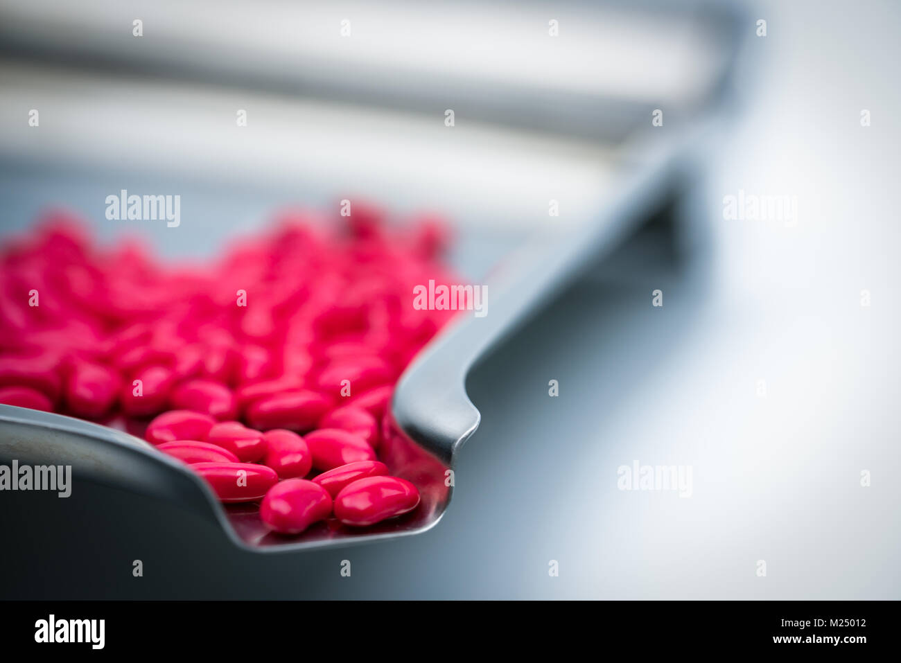 Macro shot detail of red kidney shape sugar coated tablet pills on ...