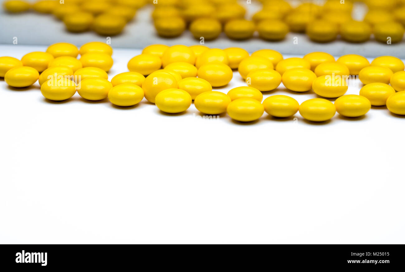 Macro shot detail of yellow round sugar coated tablets pills on blurred ...