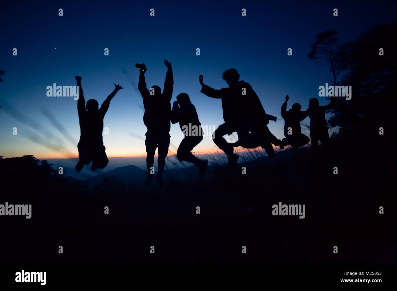 Happy friends, family jumping together in a circle having fun and ...