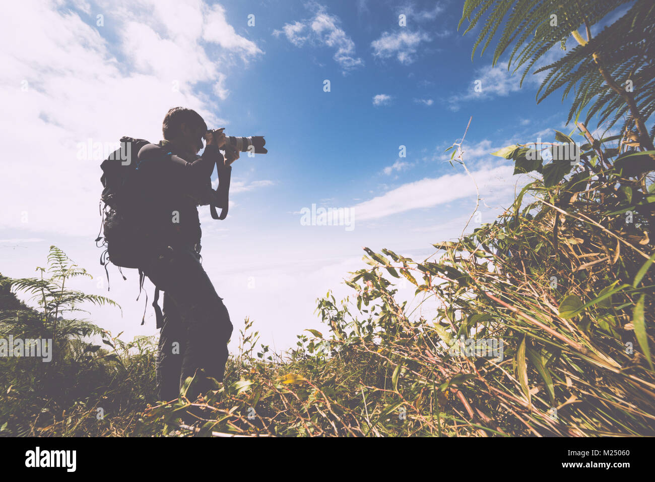 Freedom man standing on mountain and take a photo Stock Photo - Alamy