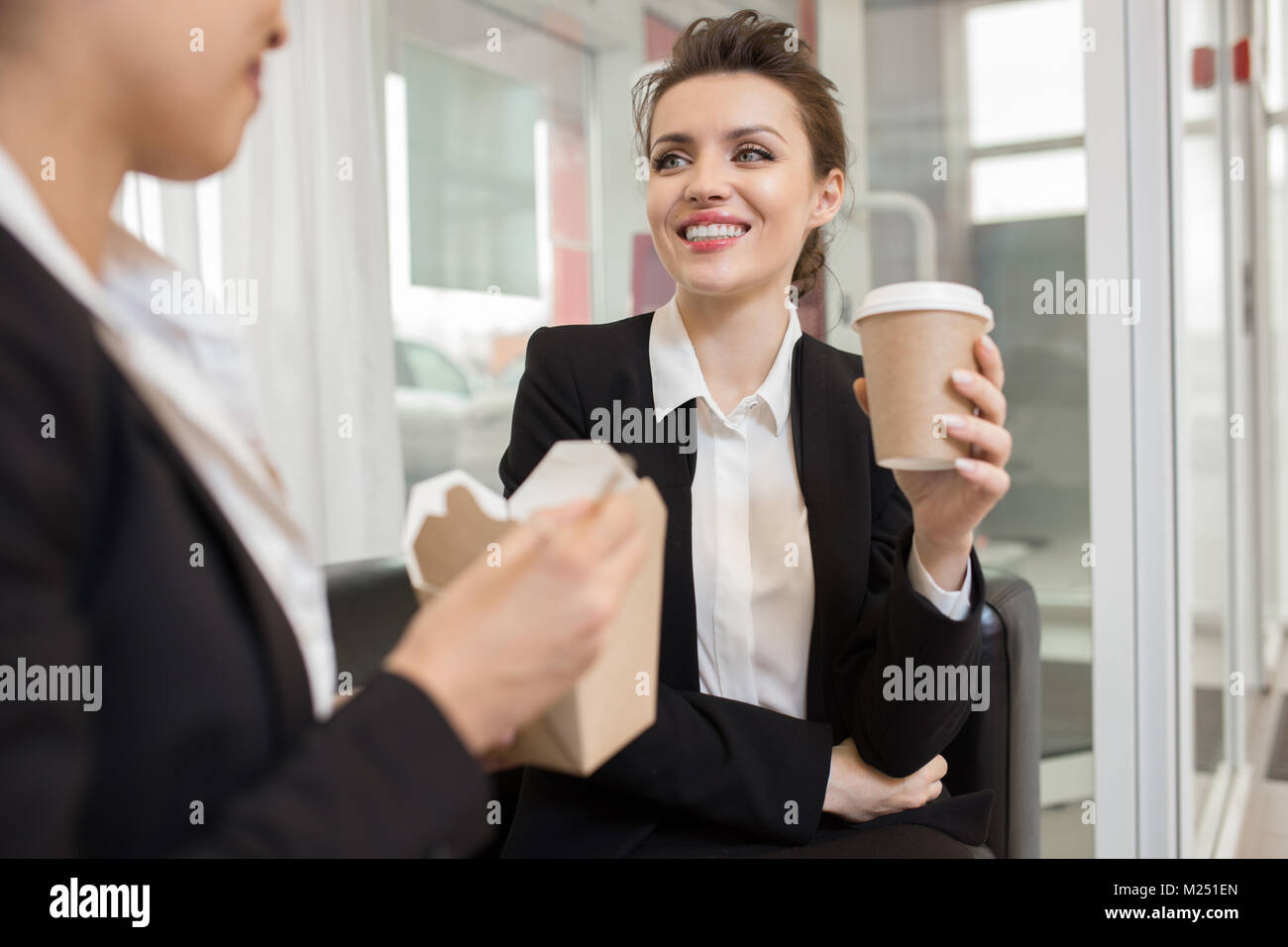 Portrait of pretty young woman eating Chinese food from boxes while ...