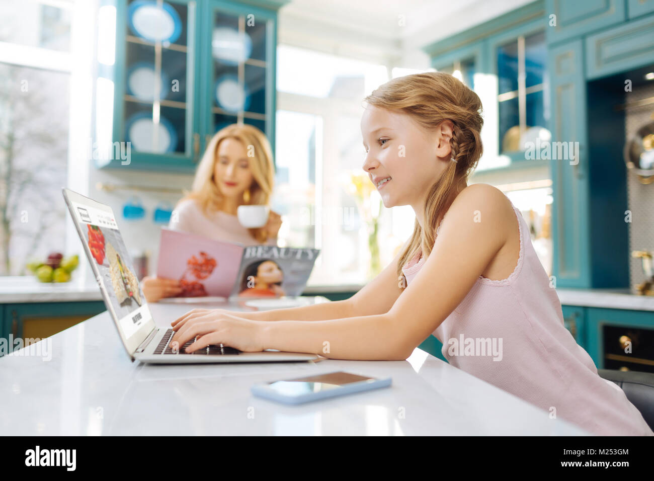 Delighted girl typing on her laptop Stock Photo - Alamy