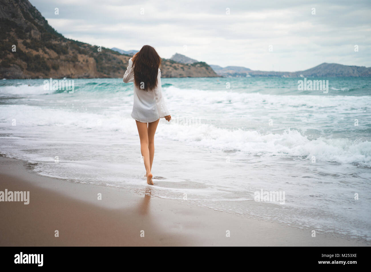 Outdoor photo of beautiful young woman walking at the sea Stock Photo ...